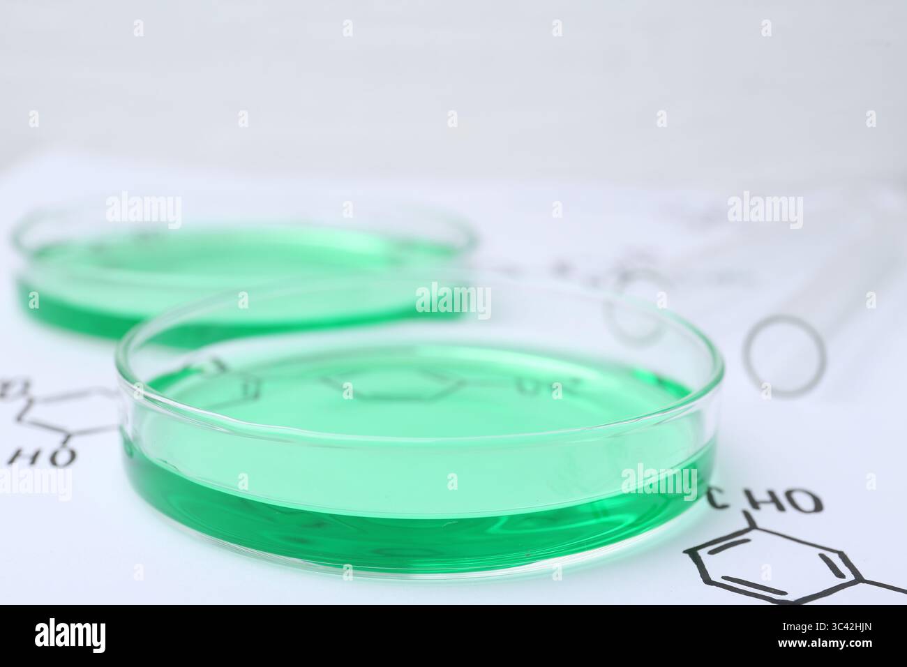 Petri dishes of samples and test tubes on paper with chemical formulas ...