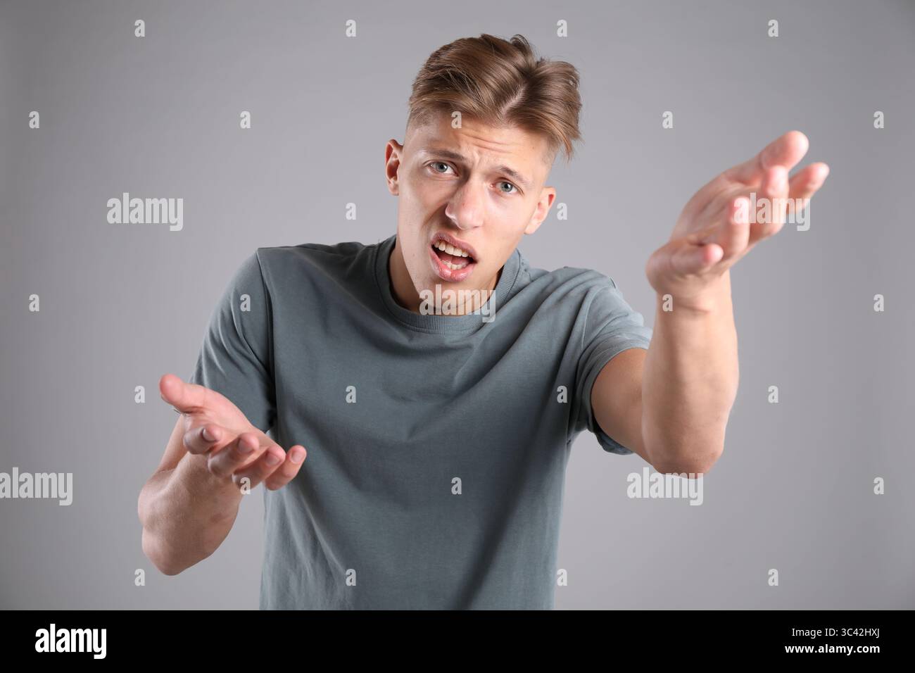 Portrait of confused man on grey background Stock Photo - Alamy