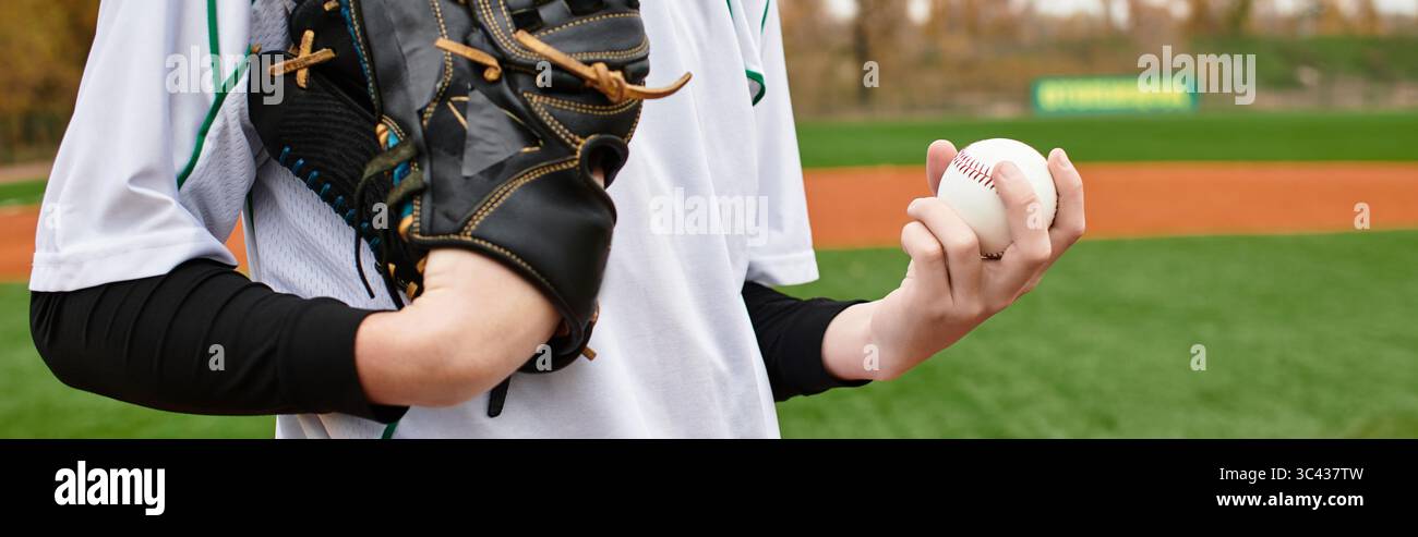 A confident player stands ready at the baseball field, glove in hand ...