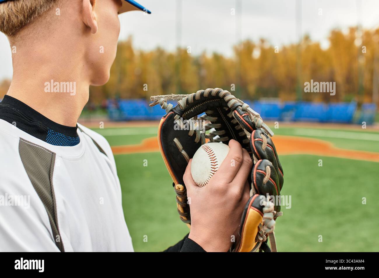 A focused player stands ready to throw a baseball, showcasing ...