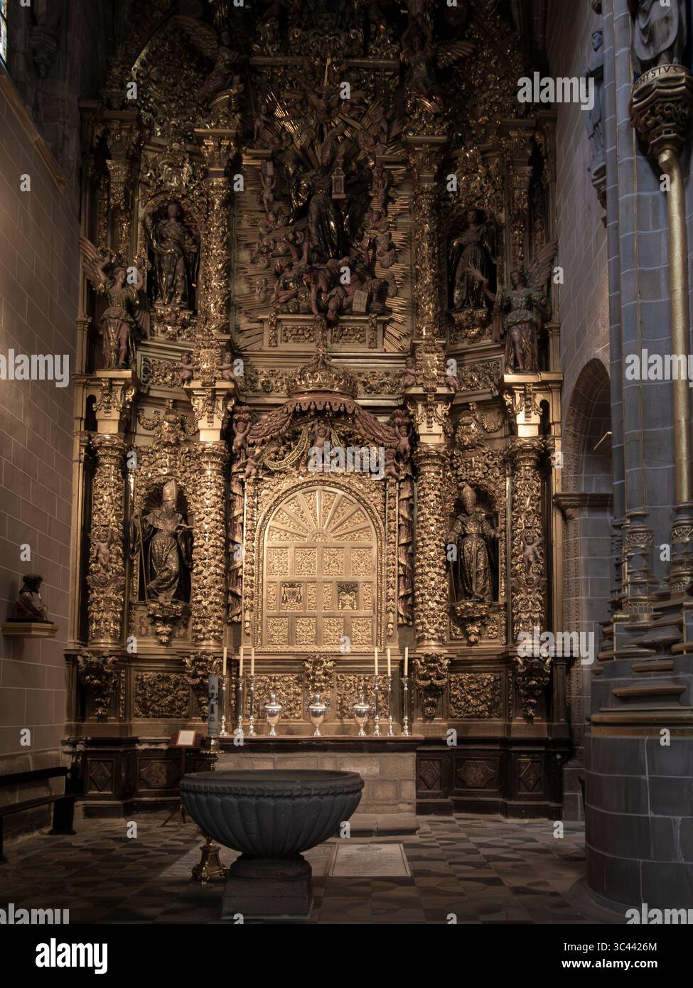 Golden altar with intricate carvings and statues, illuminating a dimly ...