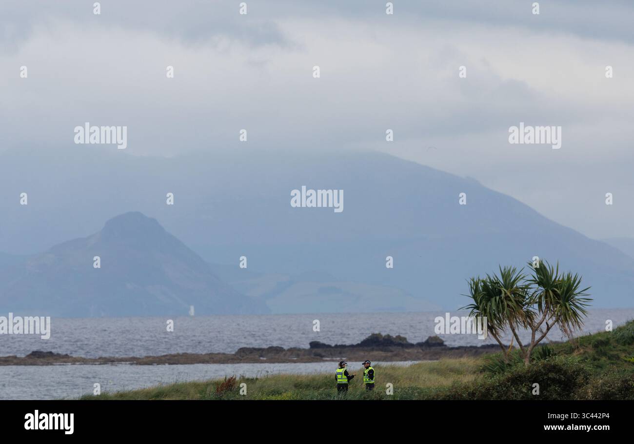 The Isle of Arran is seen in the background as police officers patrol ...