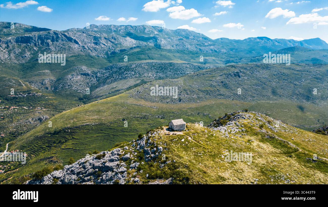 Aerial view of a solitary stone structure perched atop a rocky ridge ...