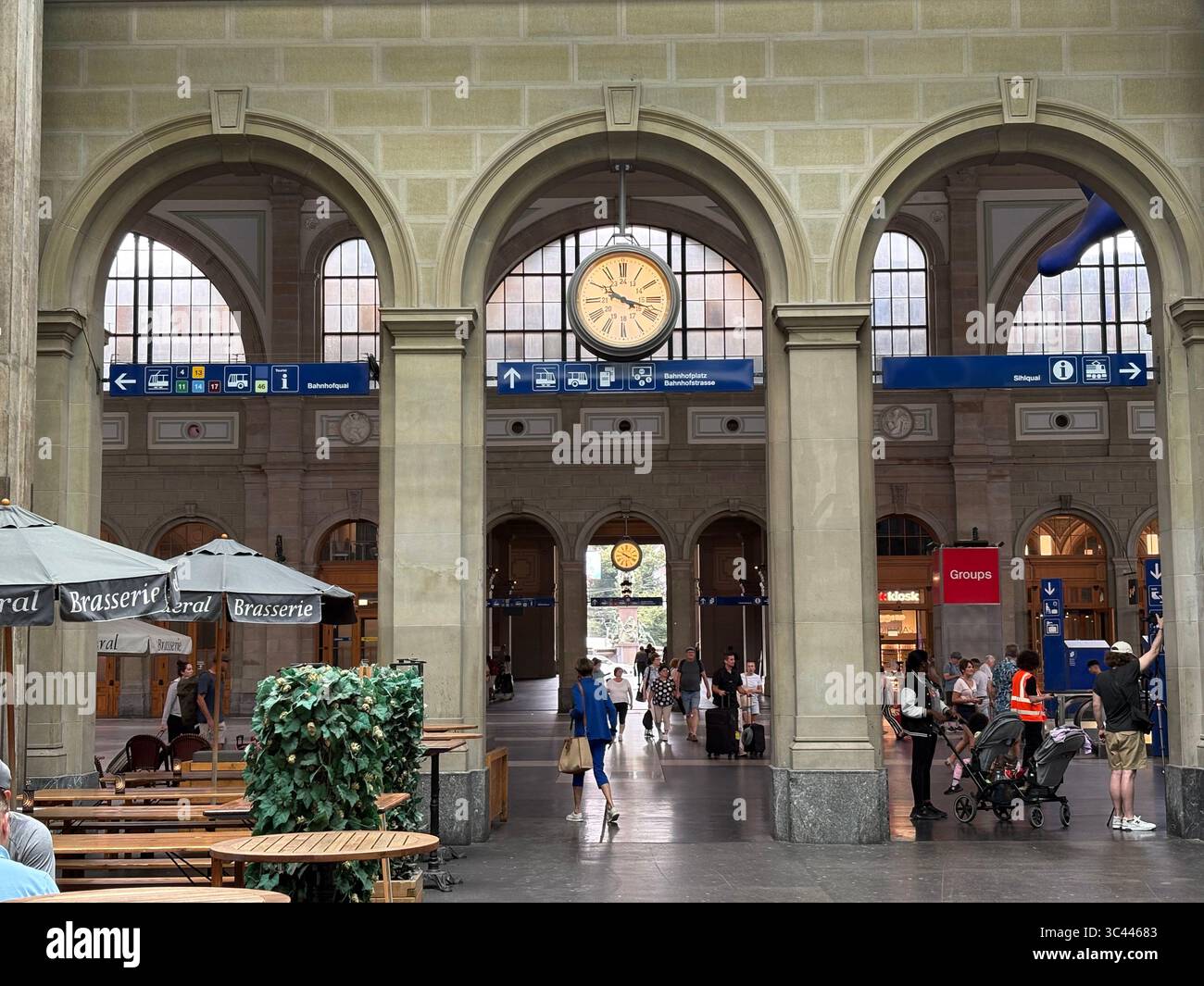Main hall of Zurich Hauptbahnhof with iconic clock, arched windows and ...