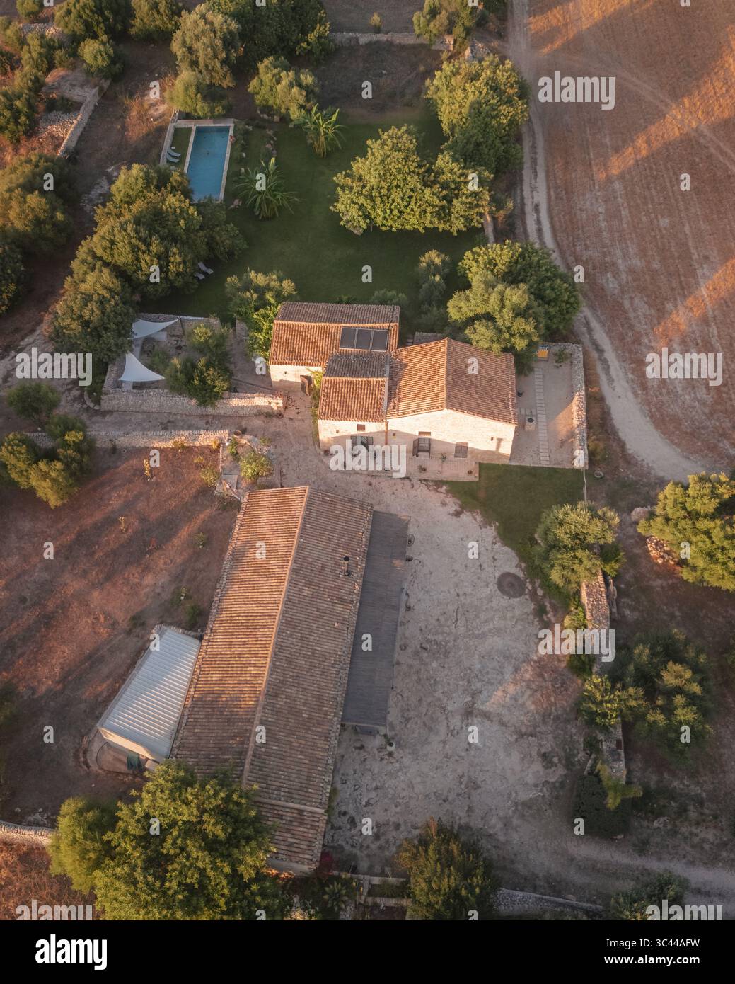 Aerial view of sun-kissed rooftops and a turquoise pool nestled among ...