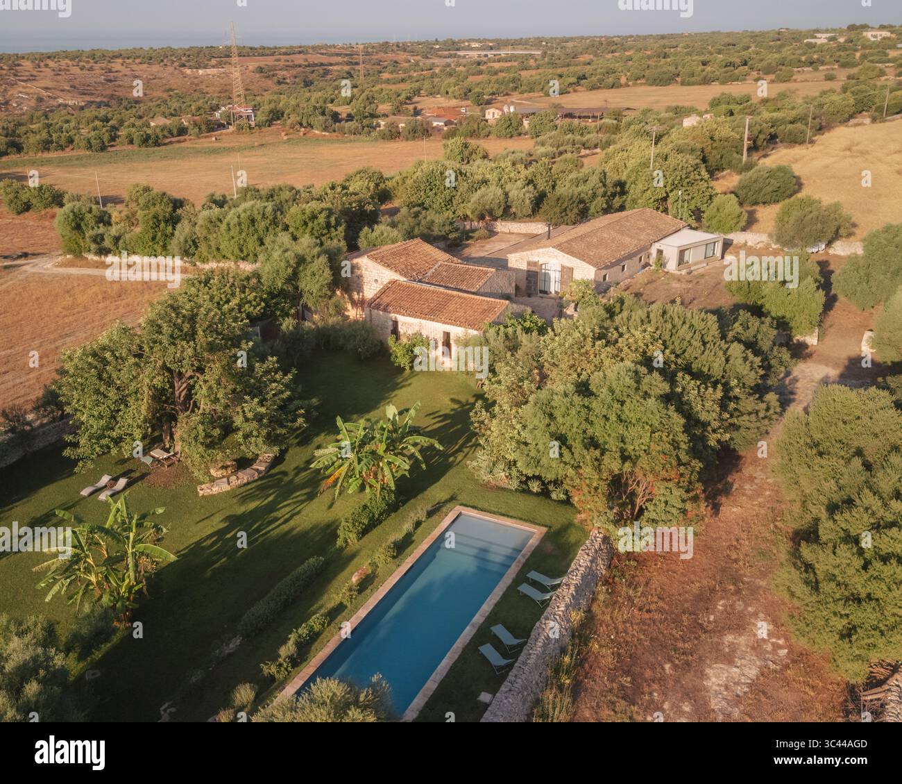 Aerial view of a serene villa with a shimmering pool nestled amidst ...