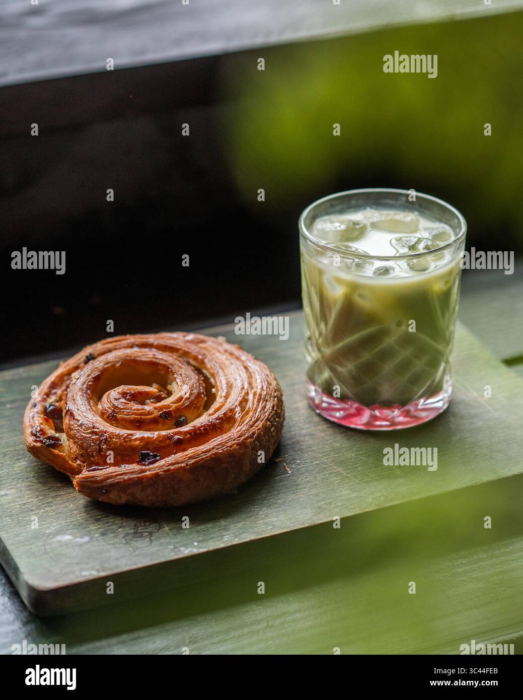 Refreshing iced strawberry matcha latte served with assorted pastries ...