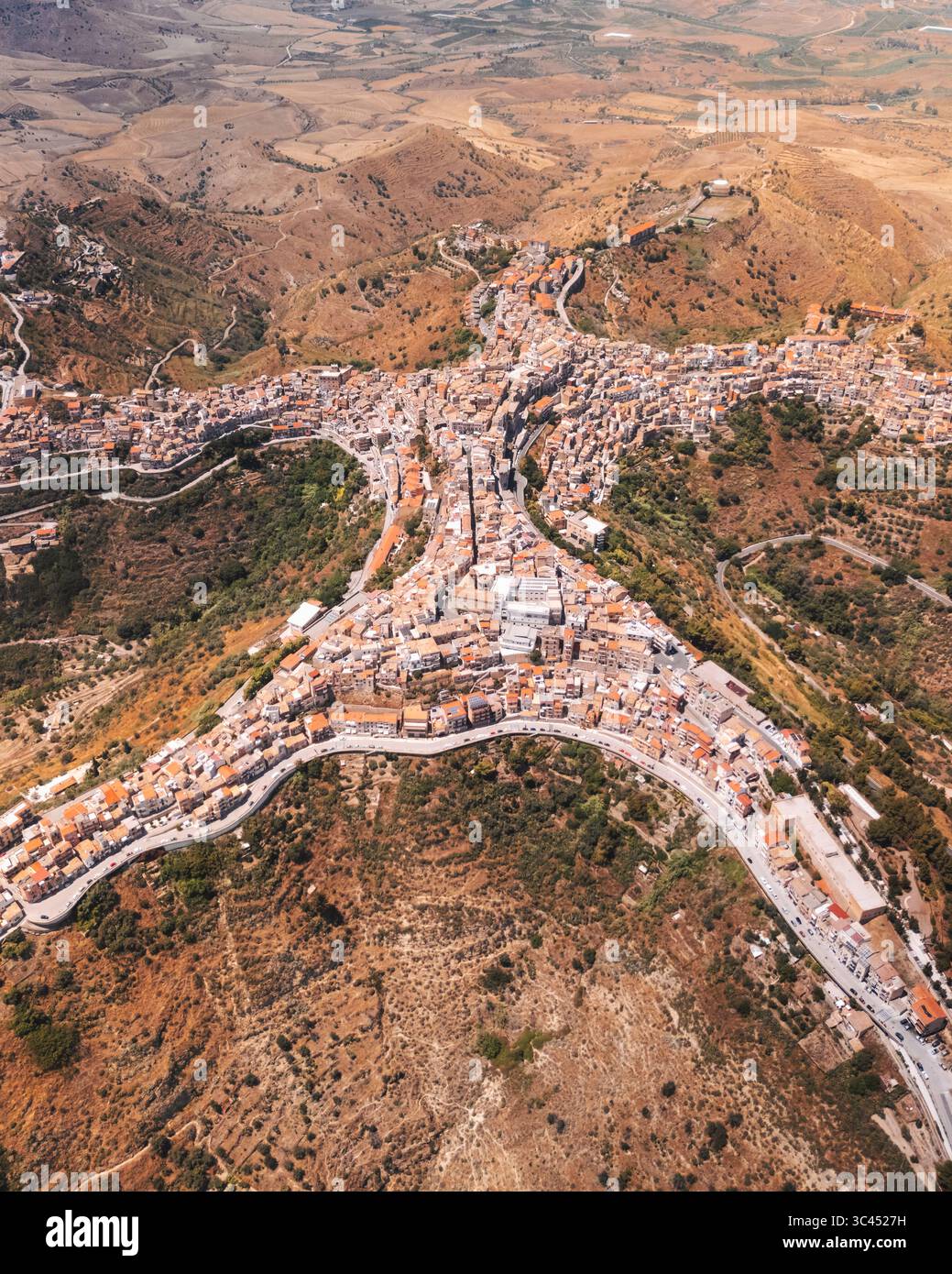 Aerial view of a town shaped like a human figure amid rugged, sun-baked ...