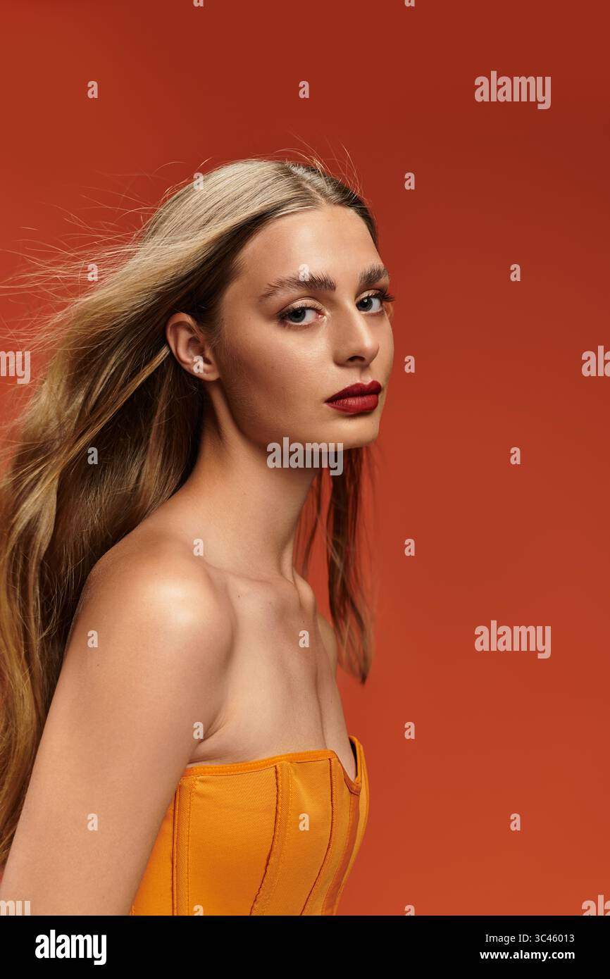 A stunning young woman poses gracefully with her long hair against a ...