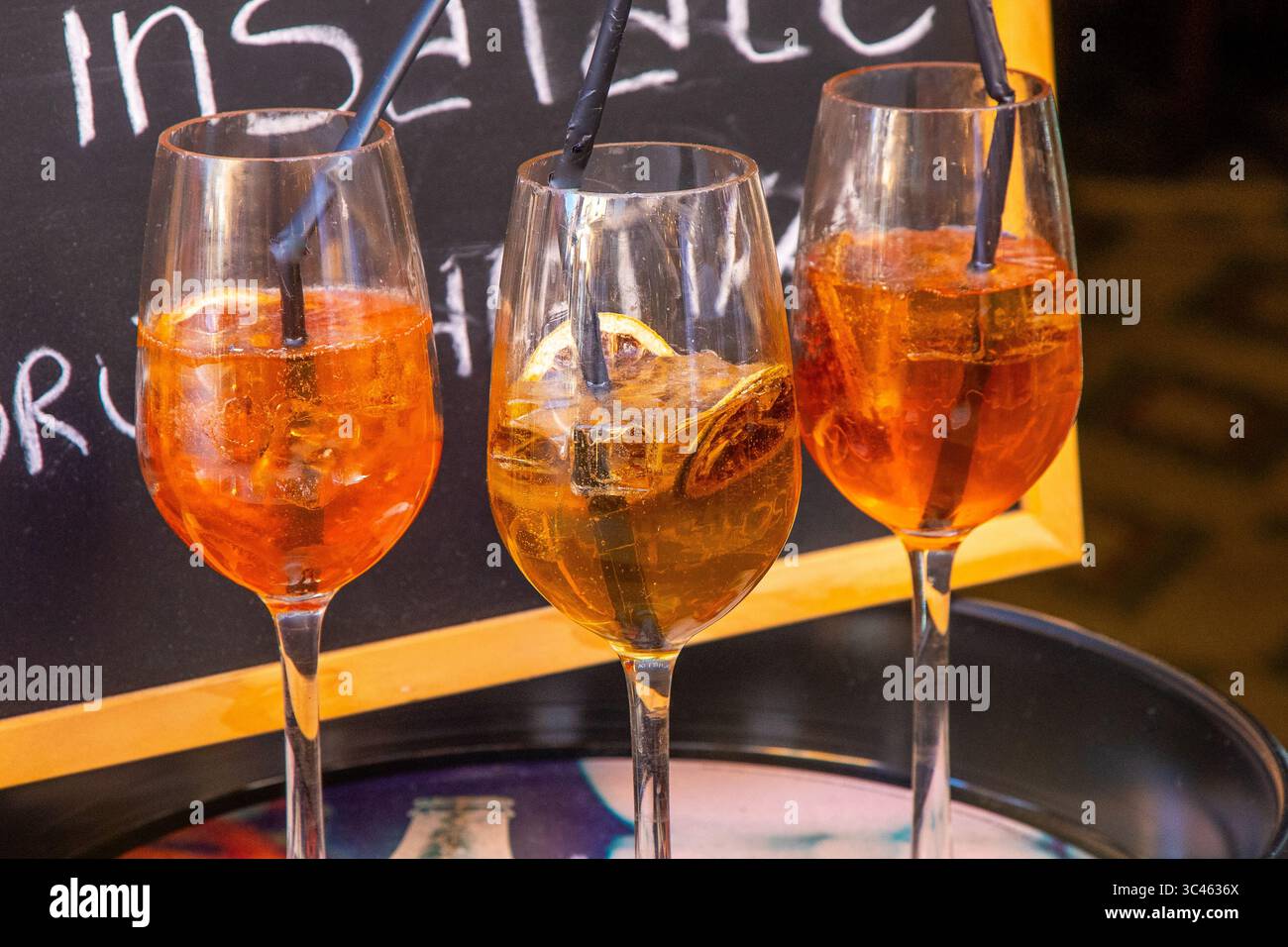 Bottle of Aperol Spitz in three glasses in bar. Italian drinks in the ...