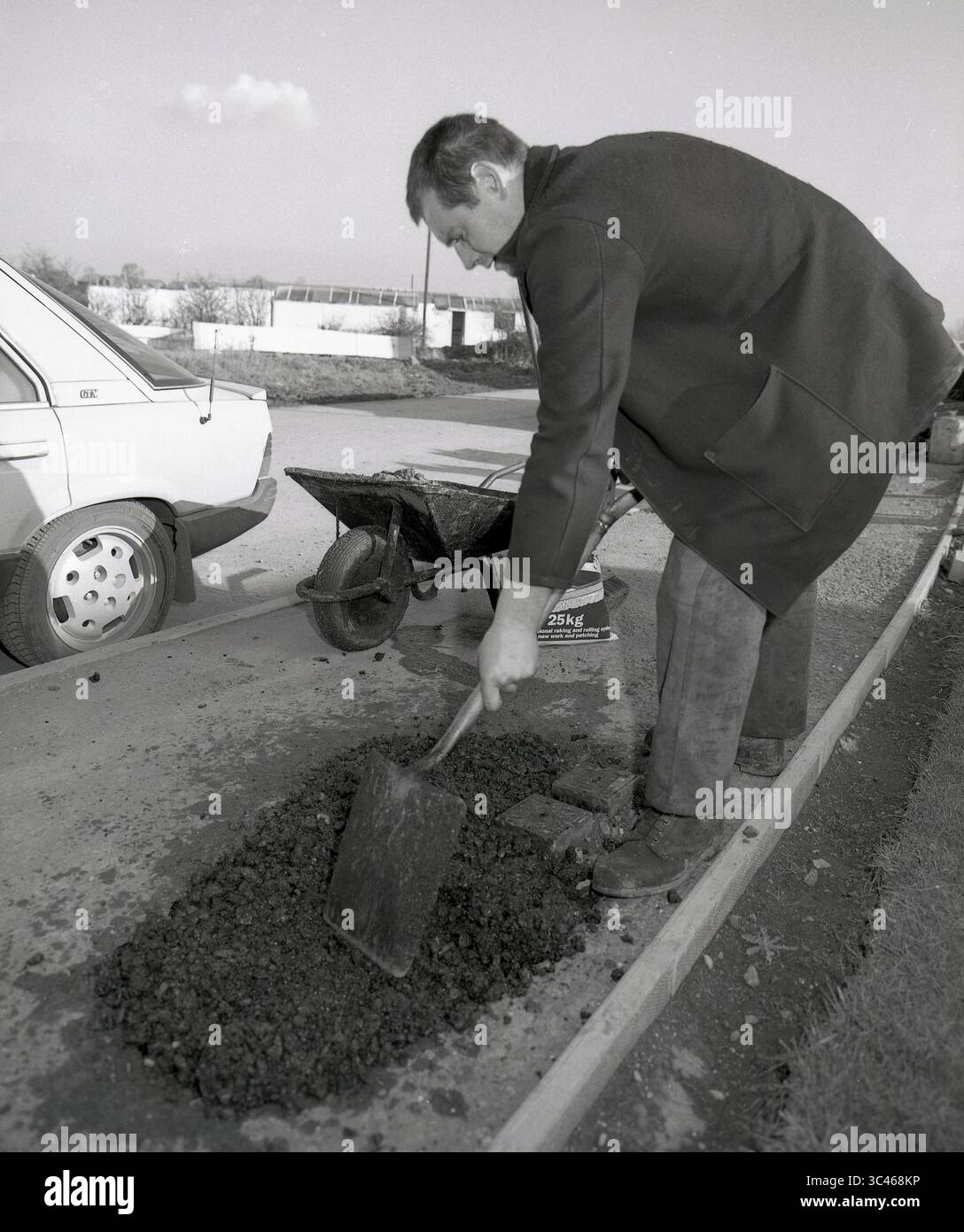 1970s, historical, man wearing a donkey jacket and boots repairing a ...