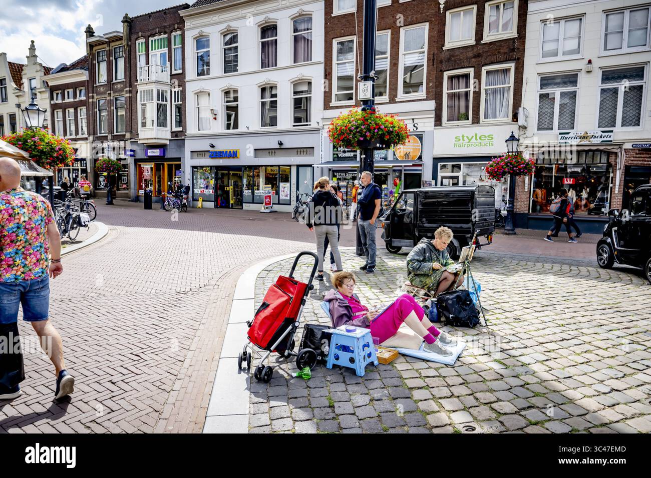 GOUDA - Two illustrators are drawing and painting the town hall on the ...