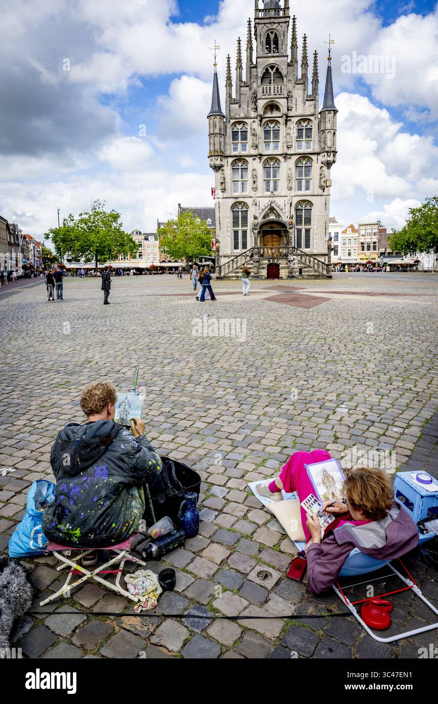 GOUDA - Two illustrators are drawing and painting the town hall on the ...