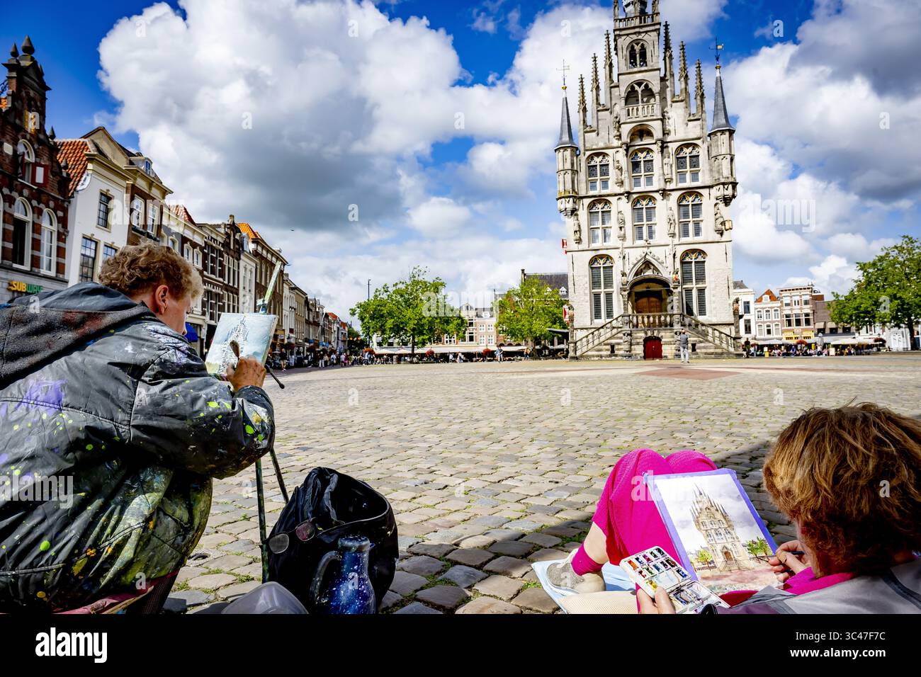 GOUDA - Two illustrators are drawing and painting the town hall on the ...
