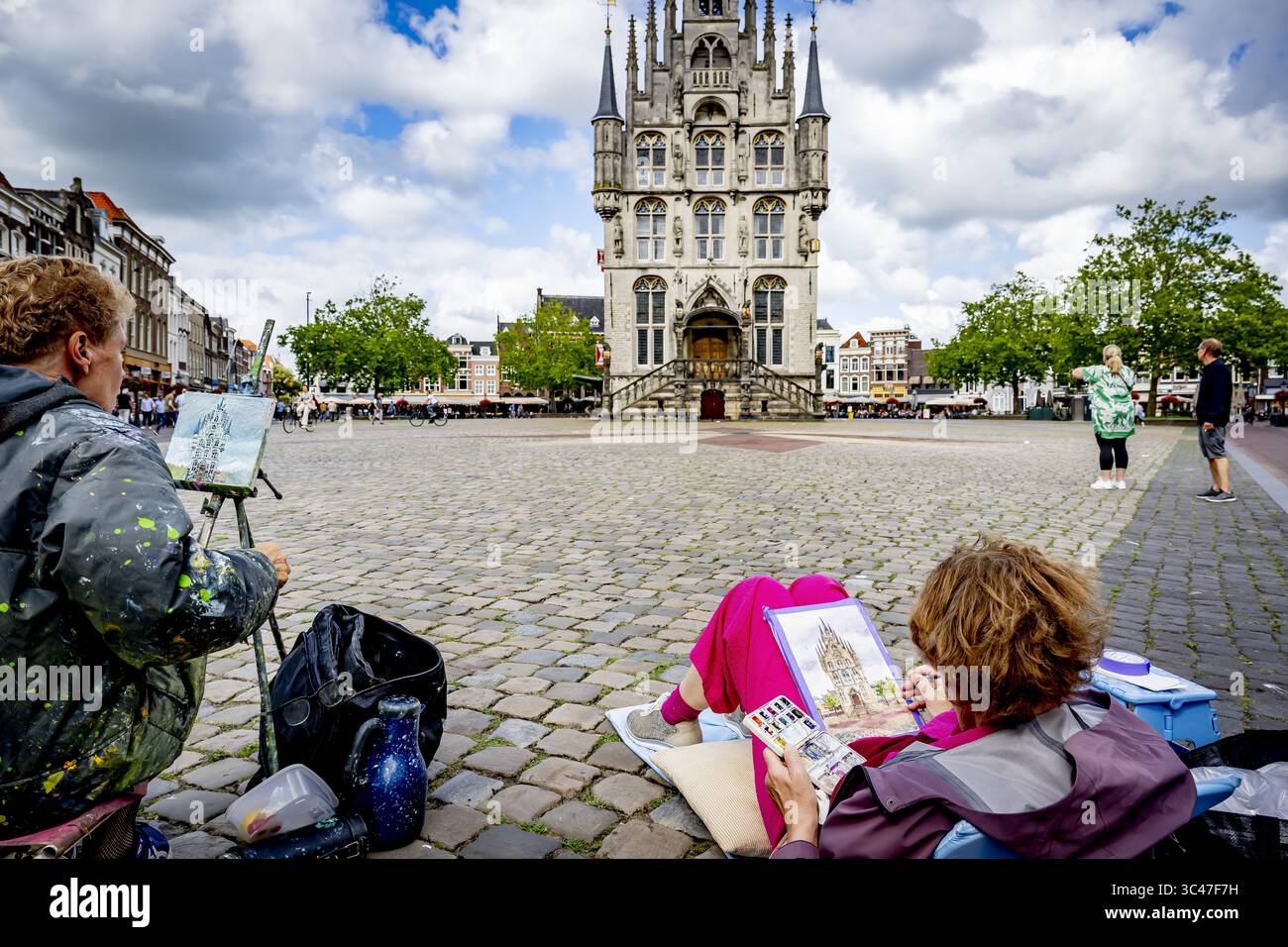 GOUDA - Two illustrators are drawing and painting the town hall on the ...