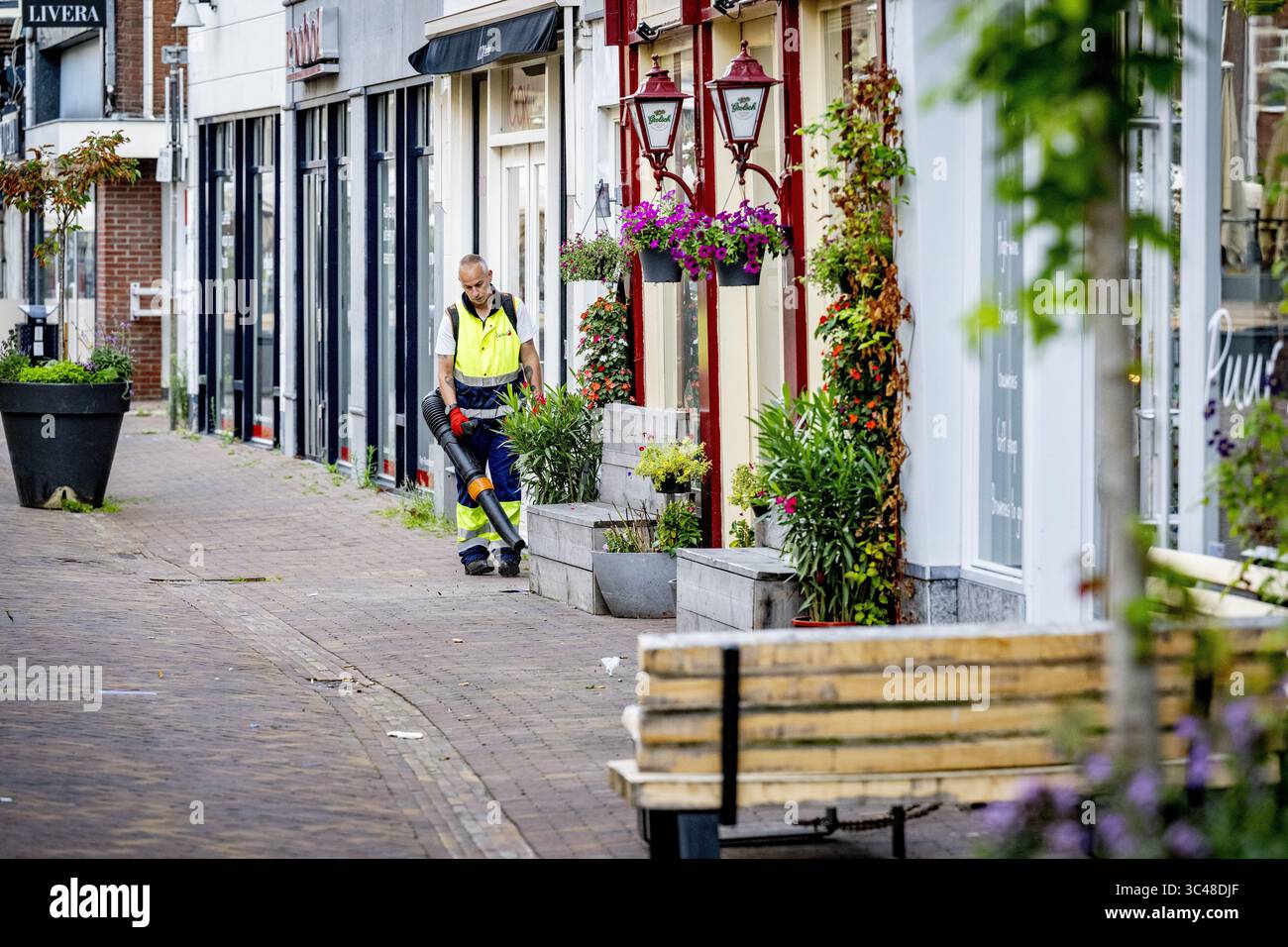 GOUDA - A municipal employee is using a leaf blower to clean up litter ...