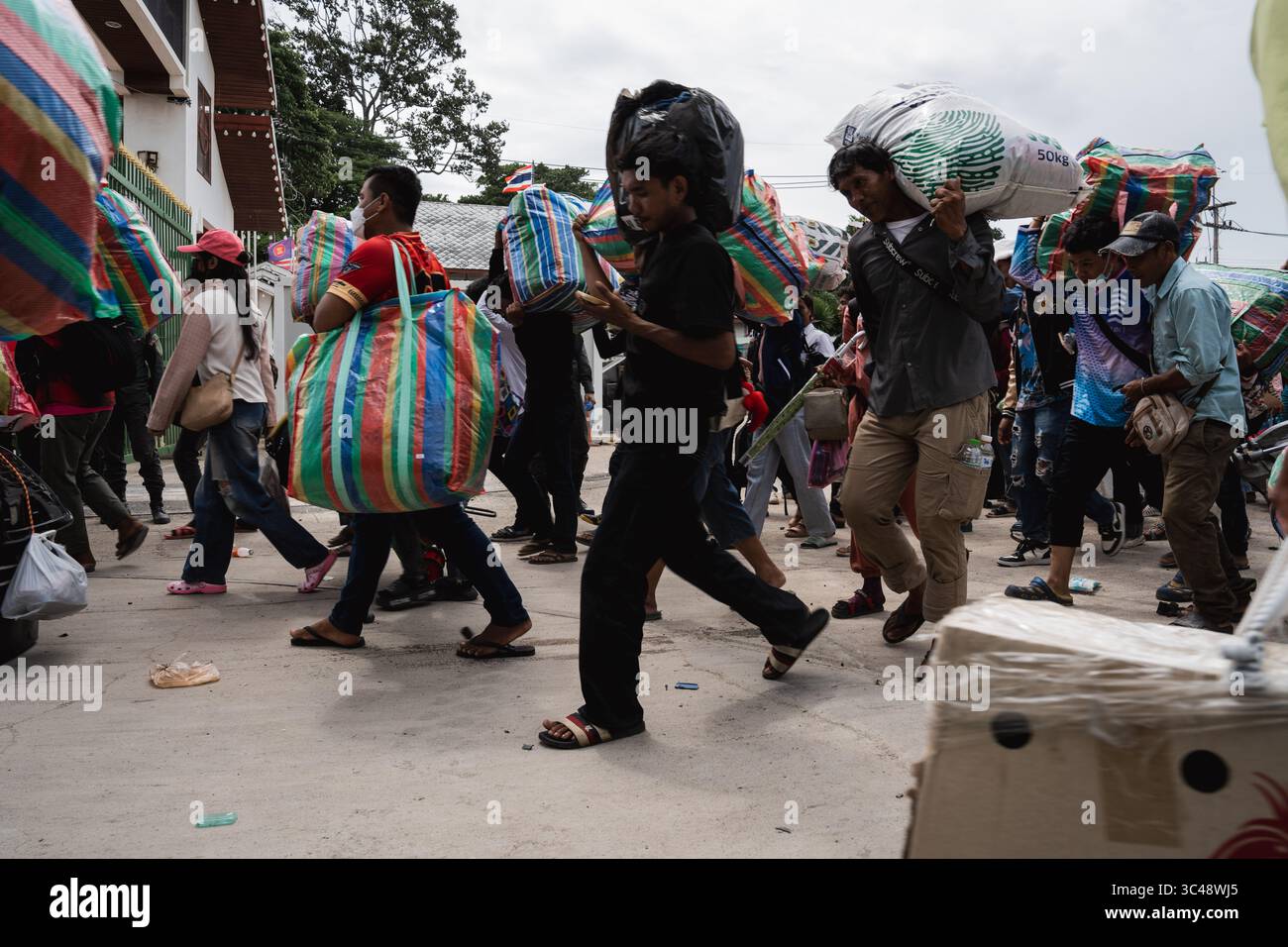 Cambodians rush toward the border gate at Ban Laem Immigration ...