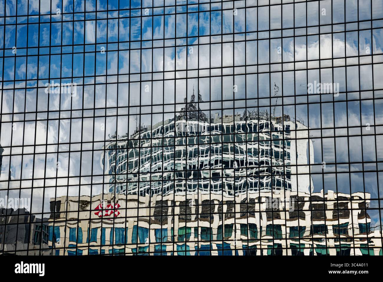 Wavy reflections of office block buildings in the glass panels of ...