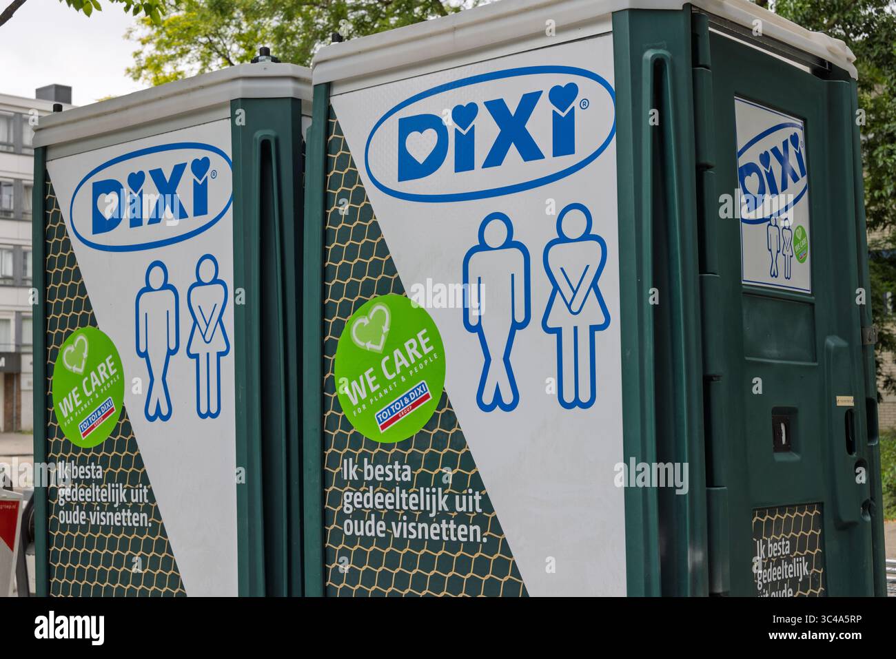 Two portable toilets, branded "DIXI," are shown outdoors. They feature ...