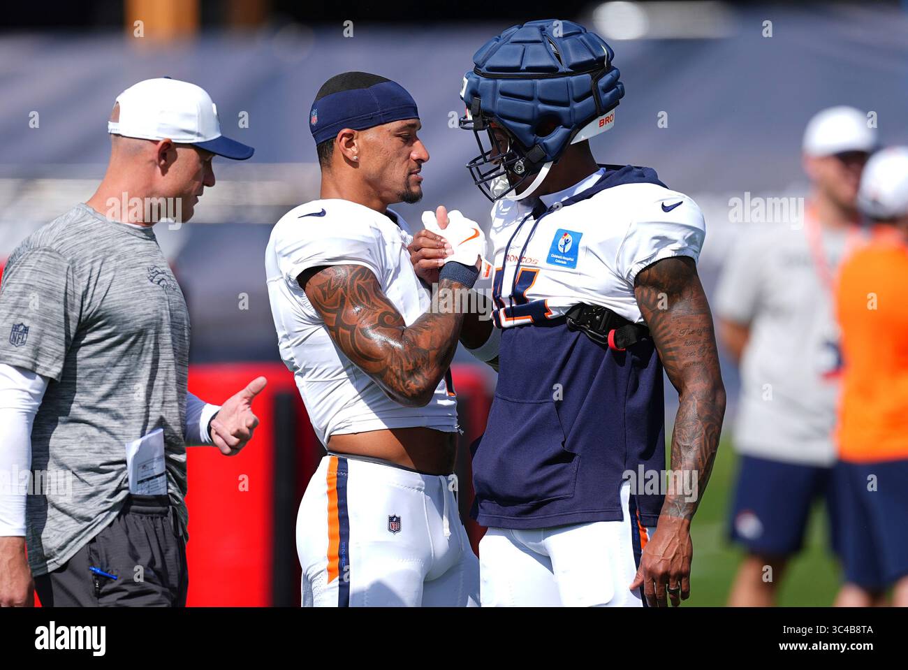 Denver Broncos tight end Evan Engram, left, greets wide receiver Courtland Sutton before taking ...