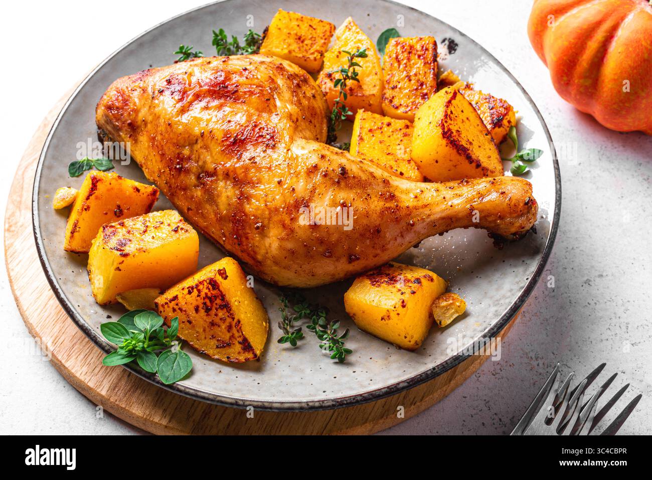 Autumn meal: roasted chicken quarter and pumpkin with garlic and herbs ...