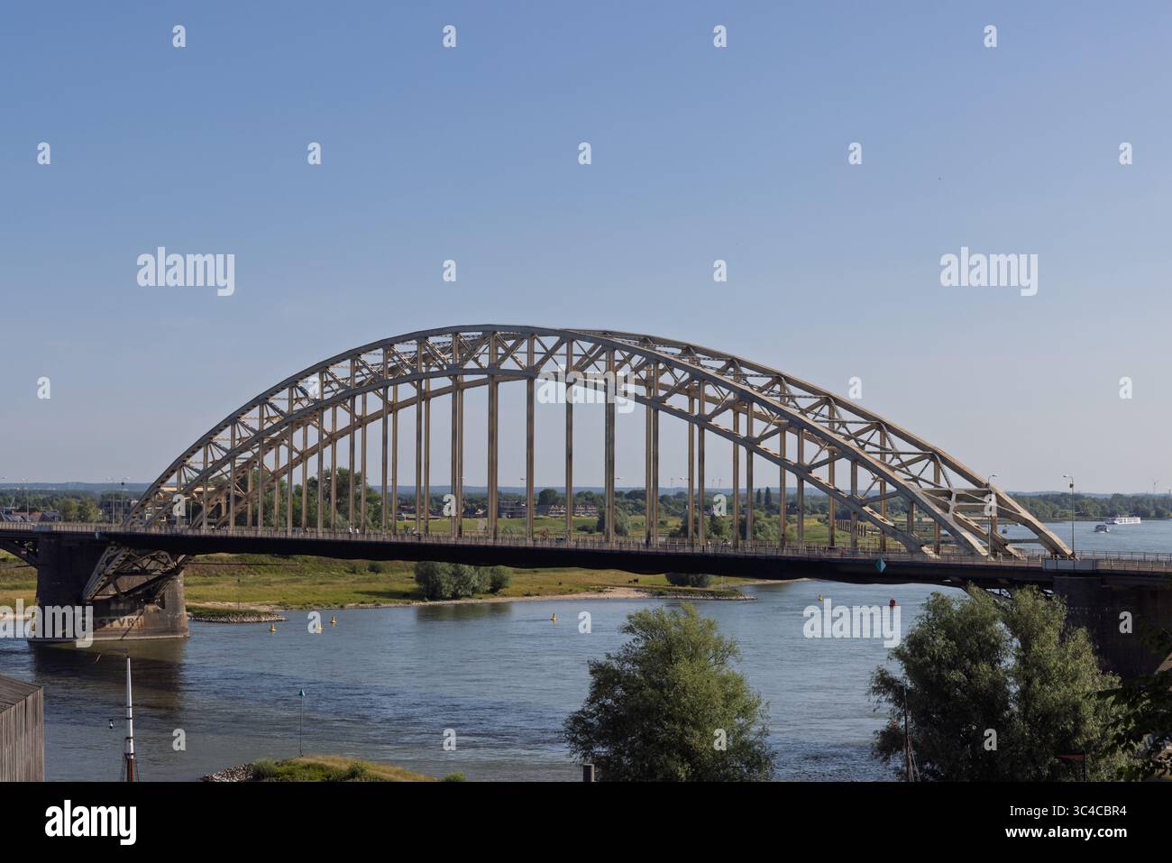 The iconic steel truss bridge, Waalbrug, spans the wide Waal river ...