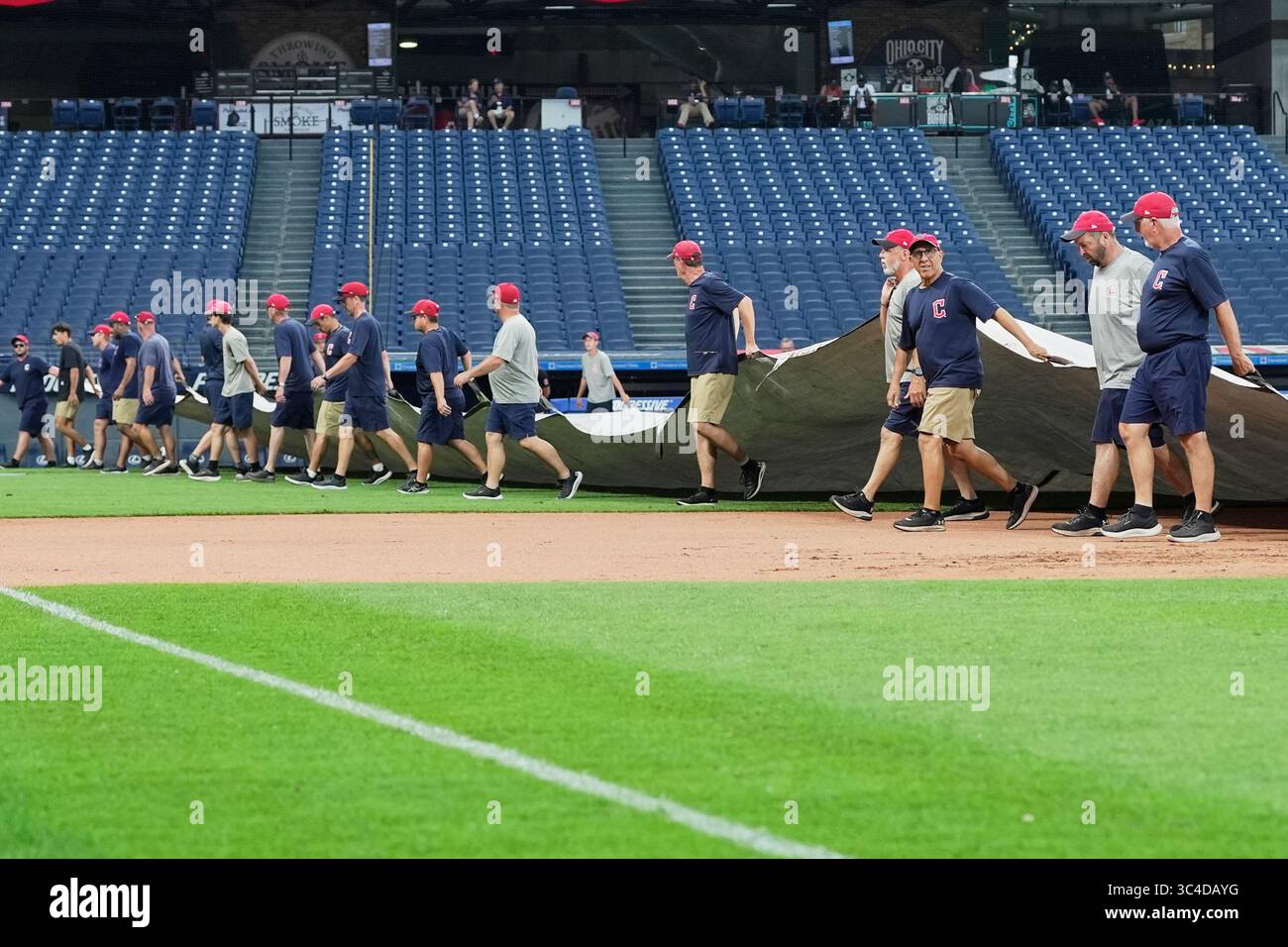 The grounds crew puts the tarp on the field in anticipation of rain ...