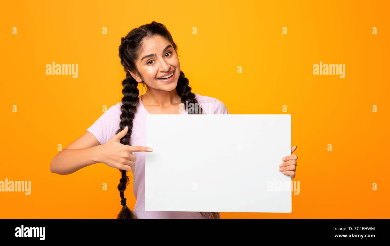 Indian woman pointing at blank white advertising board Stock Photo - Alamy