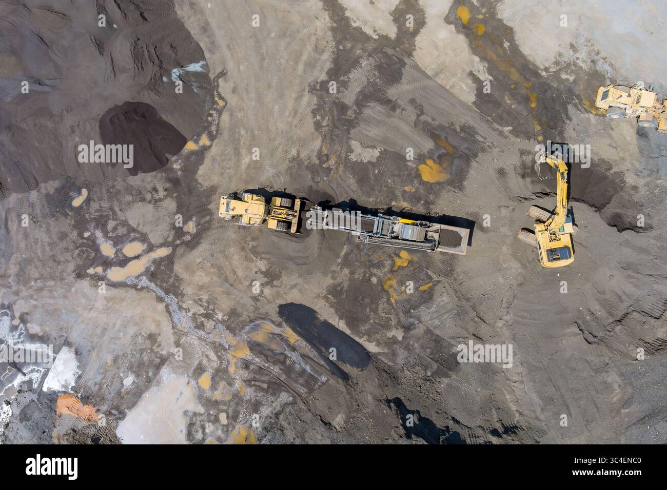 Excavators trucks operate on vast gravel extraction site under ...