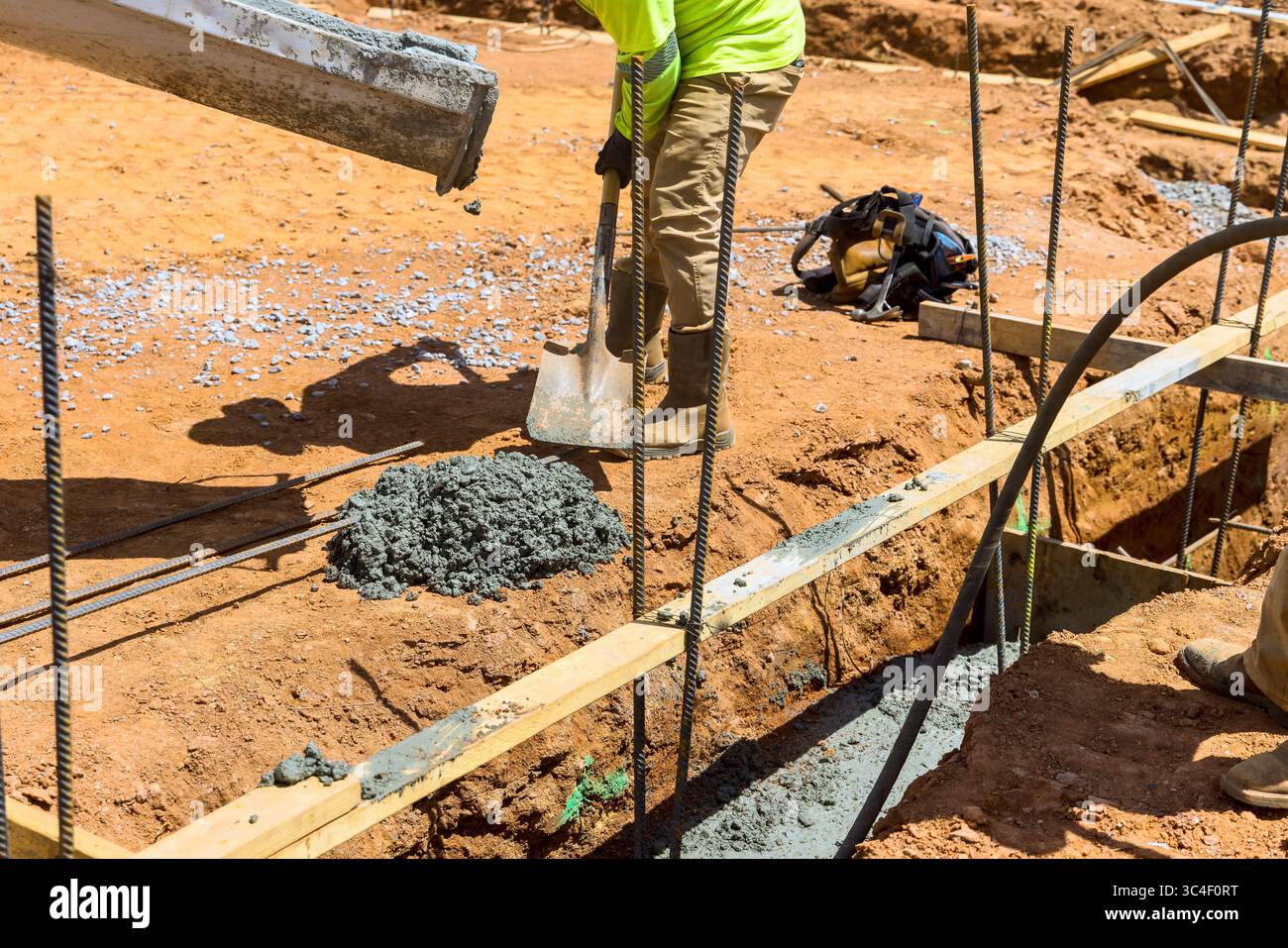 Workers are actively pouring concrete excavating soil at construction ...