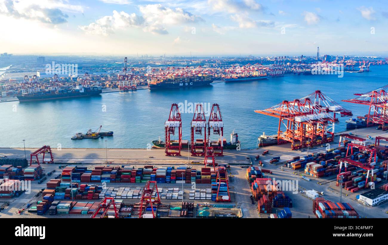 A cargo ship is loading and unloading containers at the Qianwan ...