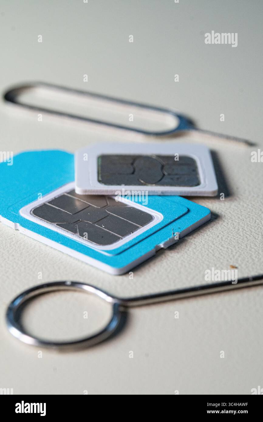 Close up macro of SIM card and SIM tray ejector tool. Perfect for tech blogs, smartphone repair ...