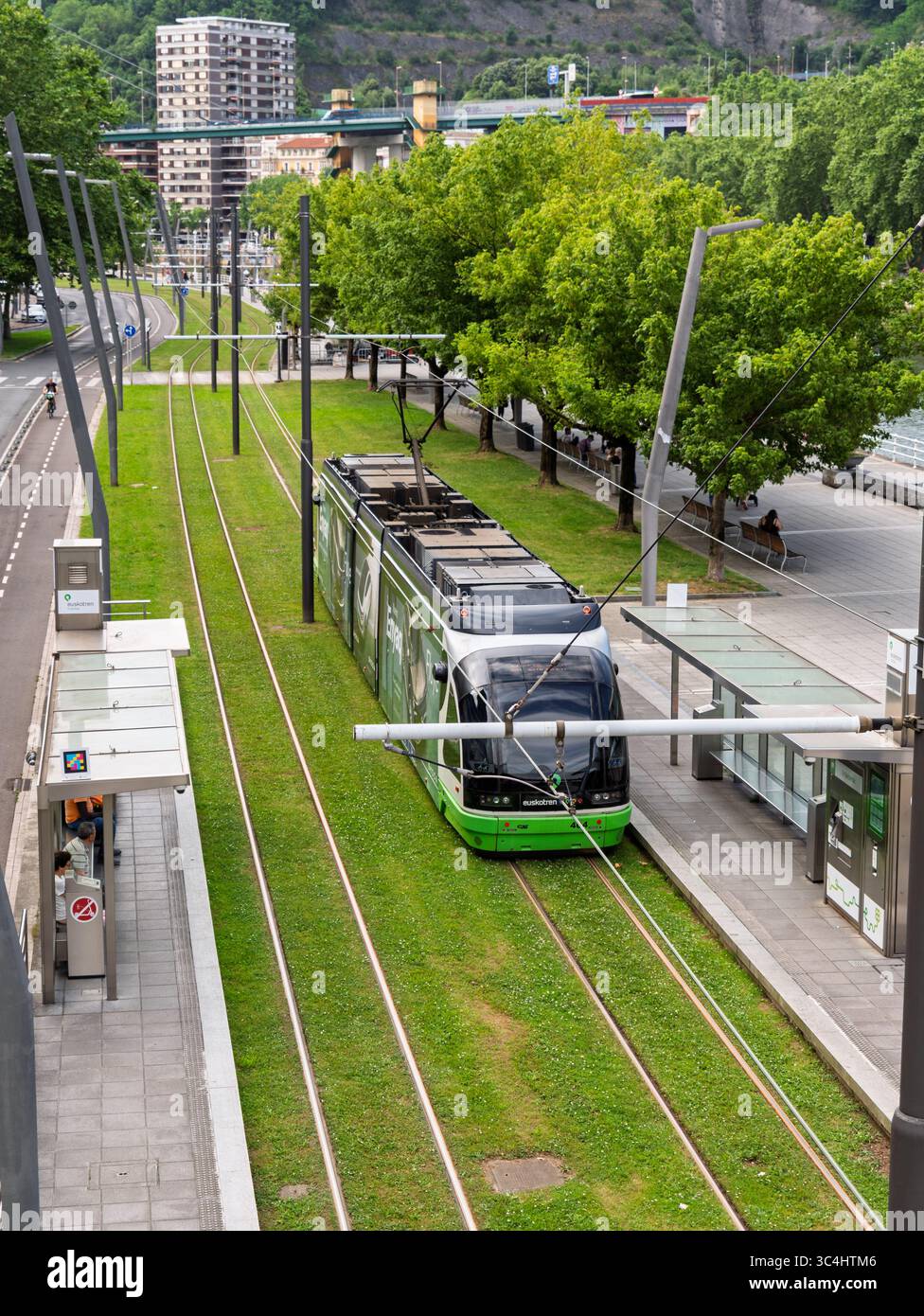 Bilbao Spain 16 06 2025 A modern green tram runs on grass-covered ...