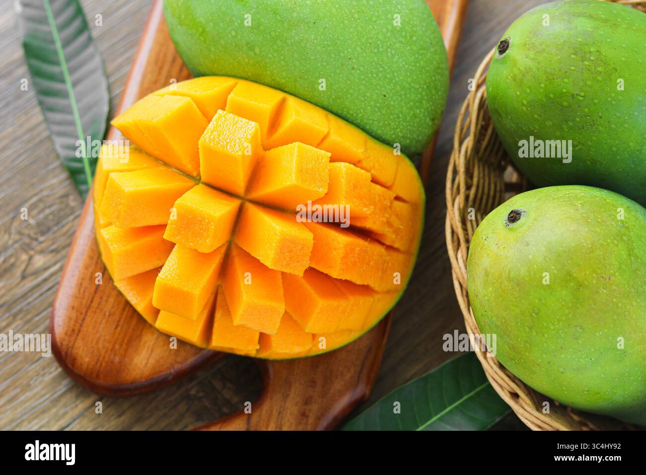 An overhead view of a juicy ripe mango sliced in a grid pattern and ...