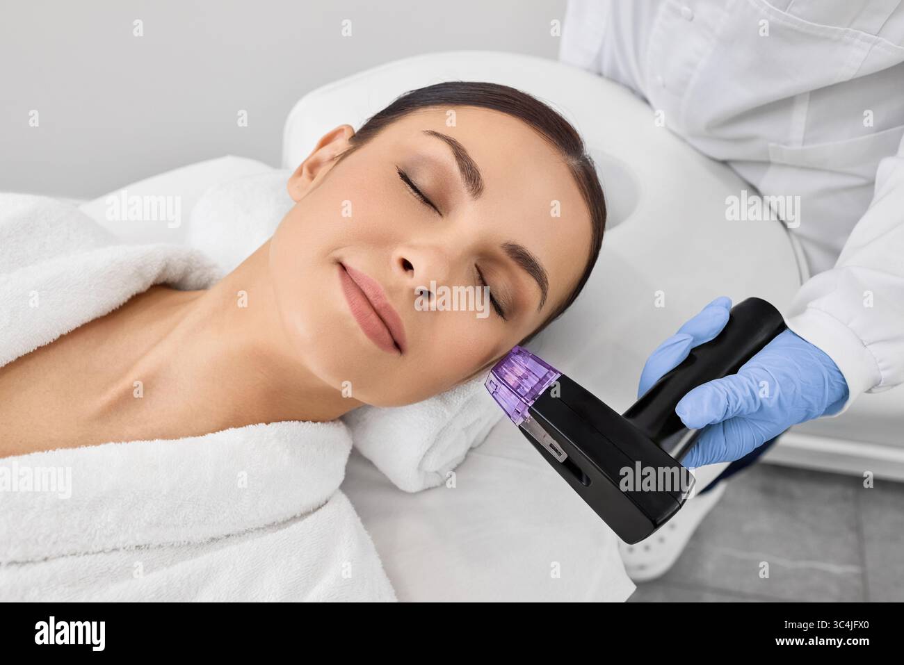 Pretty woman enjoying radiofrequency lifting procedure for her face ...