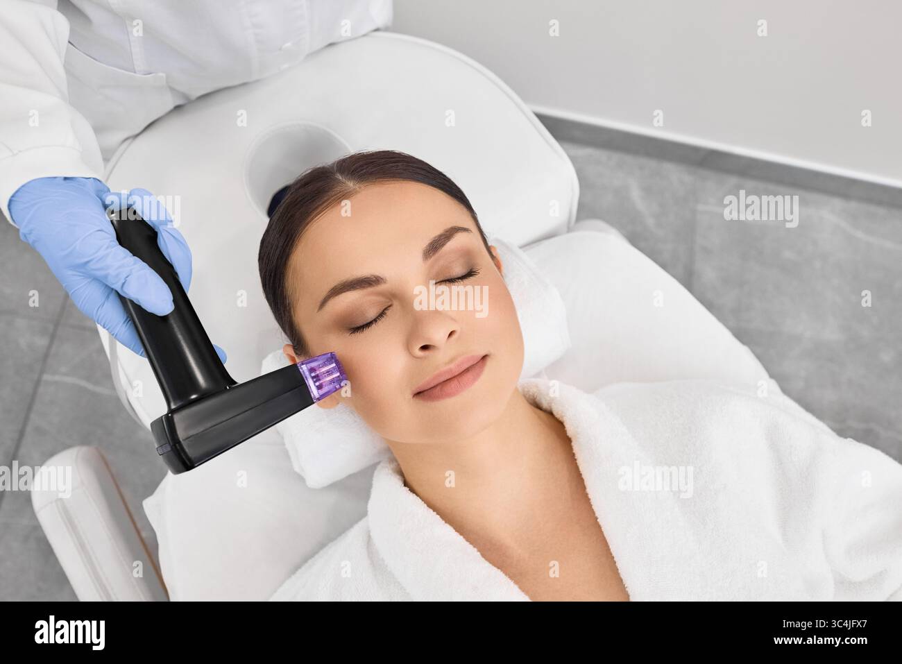 Brown haired woman receiving radiofrequency lifting procedure around ...