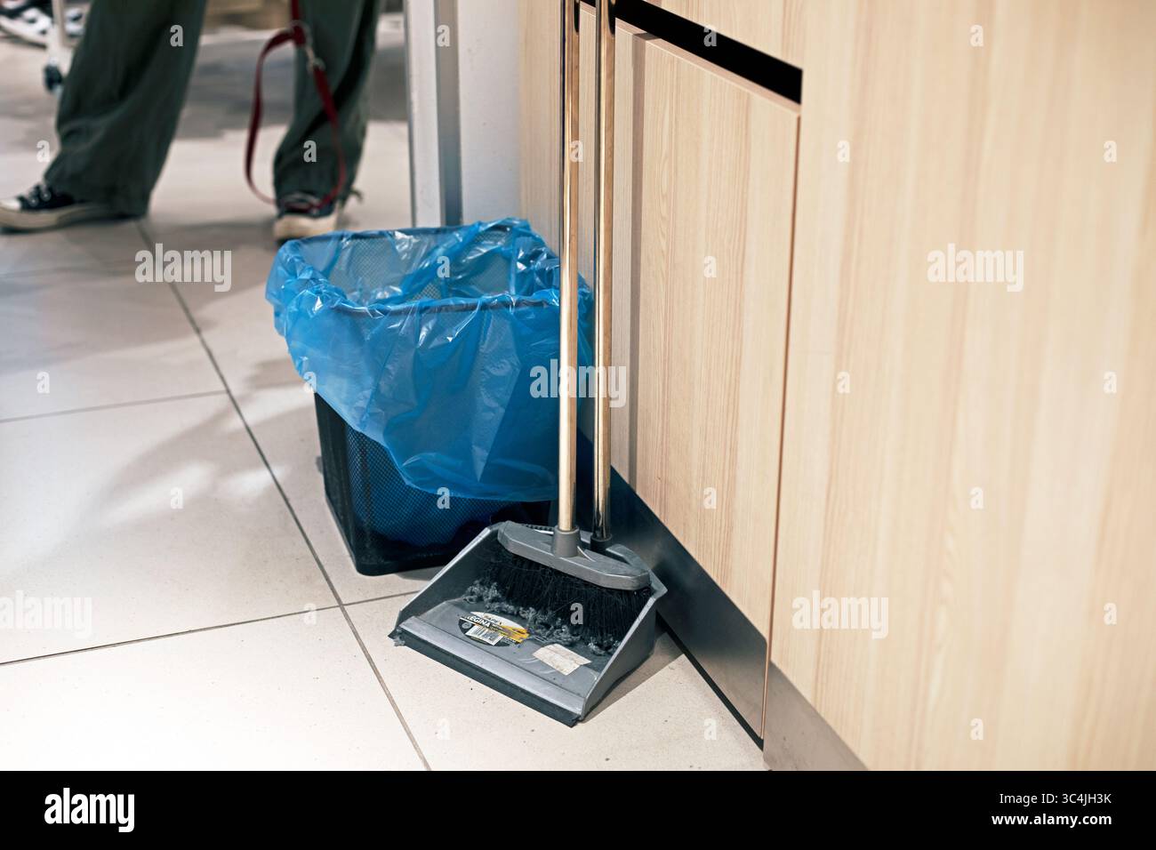 trash can with trash on a dustpan near a fitting room in a shopping ...