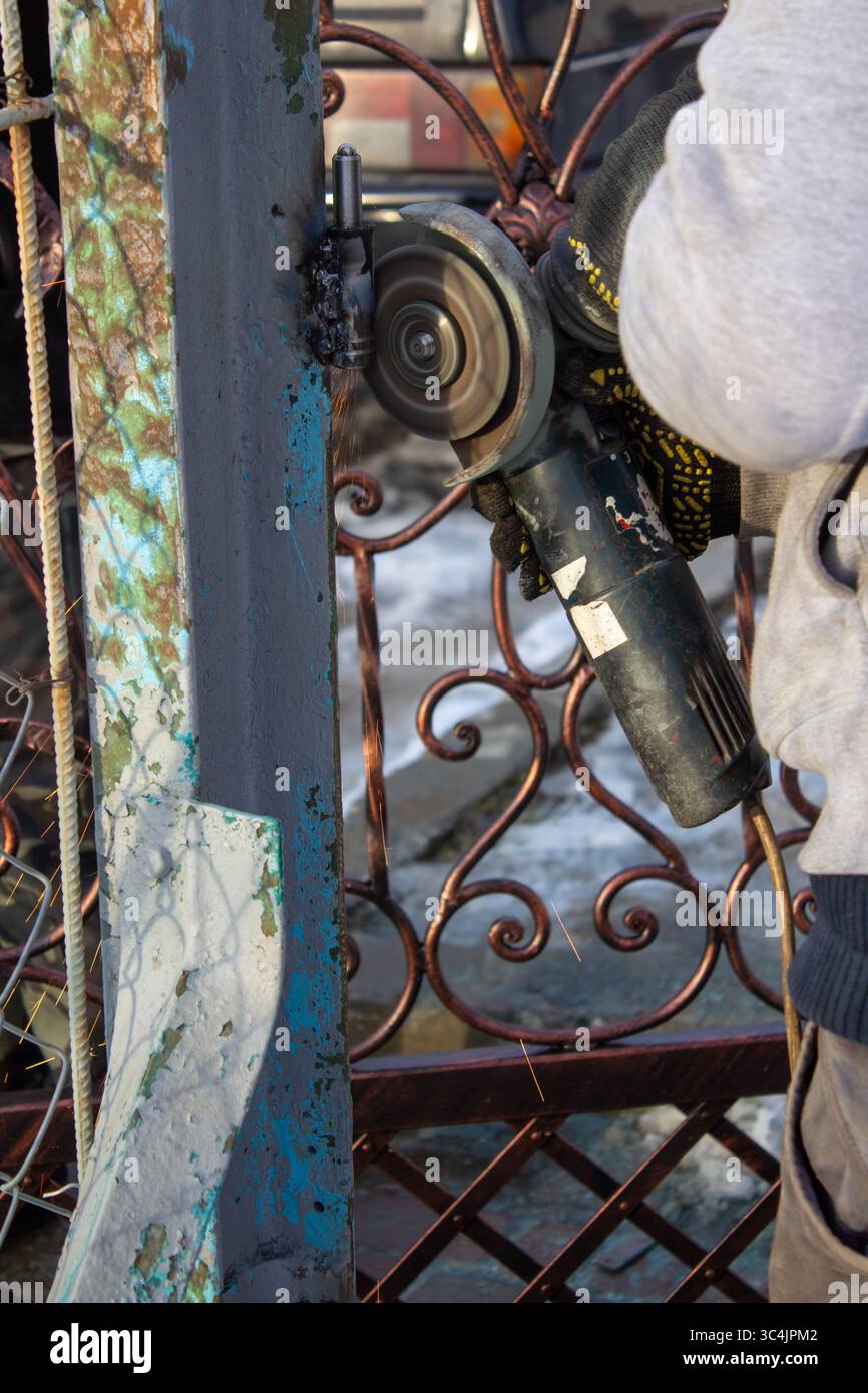 man working with Angle grinder, clean rust on gate with grinder tool ...