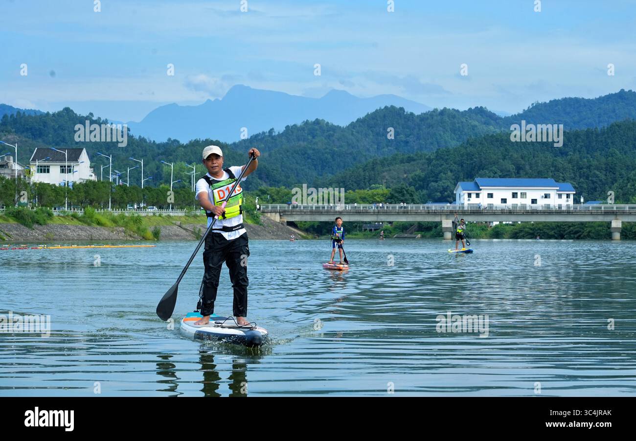 People enjoy paddle boarding on the river in Ganzhou City, east China's ...