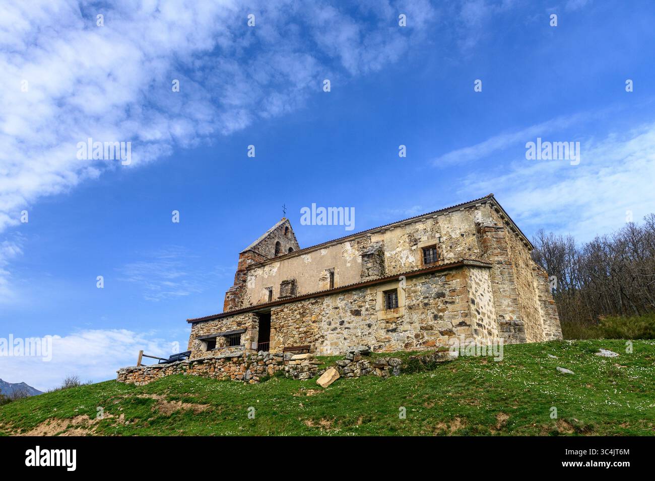 Historic stone church with cylindrical tower and bell gable on a ...