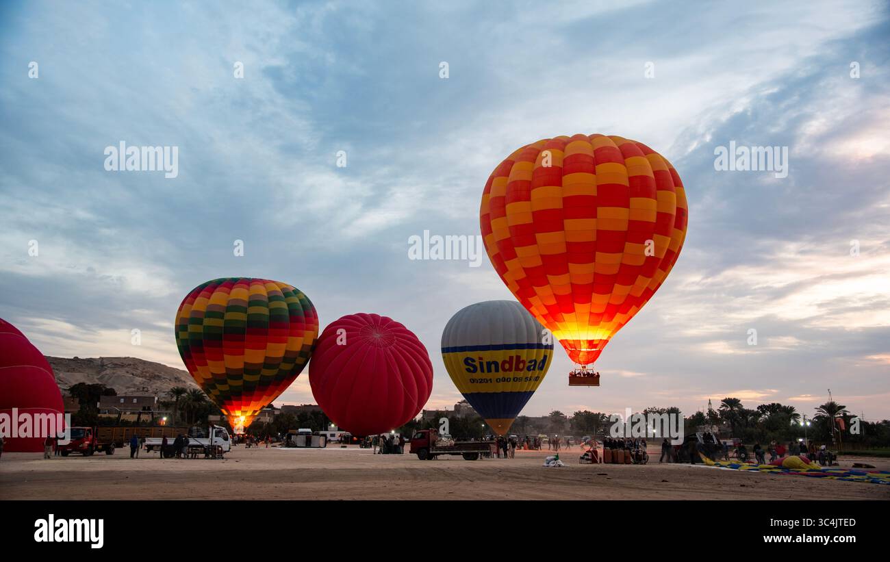 Colorful hot air balloons prepare for sunrise flight over ancient sites ...