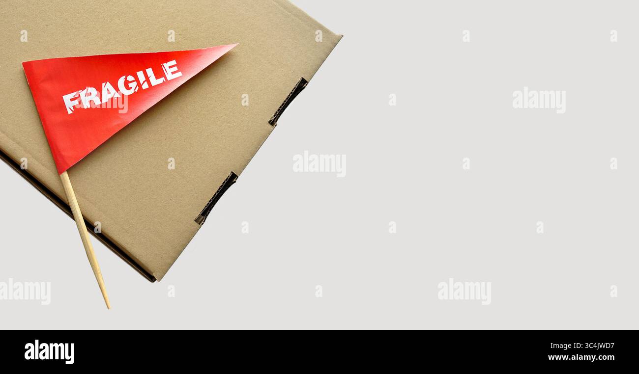 Red flag on package. Warning sign 'Fragile'. Cardboard box. Fragile ...