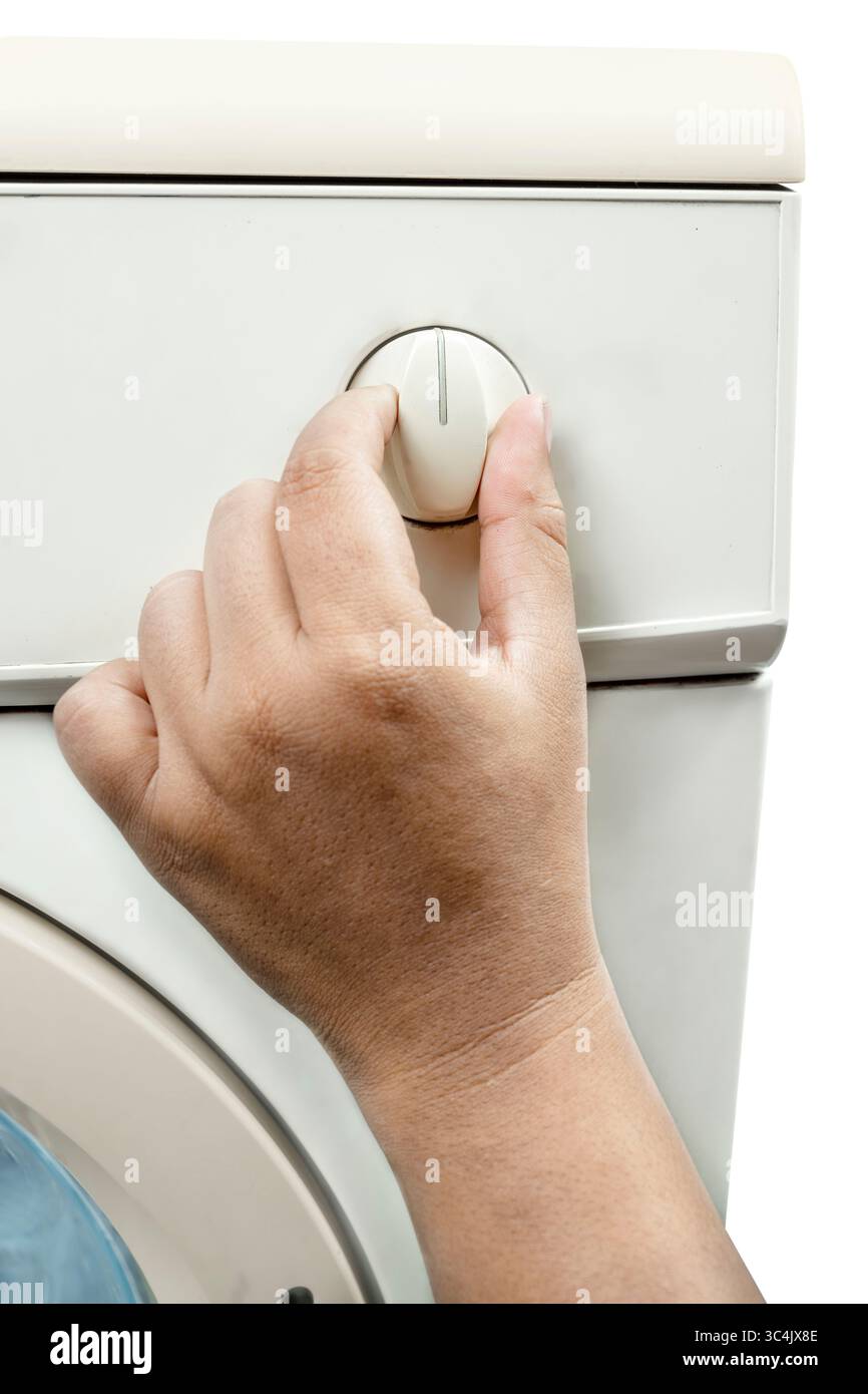 Human hand operates the knob and control panel button in a washing ...