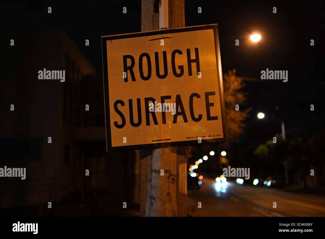 Yellow and black rough surface traffic sign, attached to a power pole ...