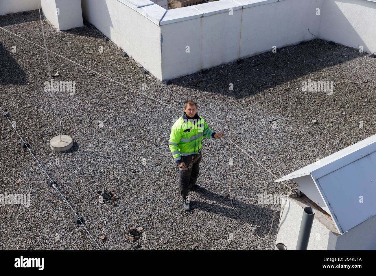 Worker in Safety Gear on Rooftop: Ensuring Safety Protocols While Using ...