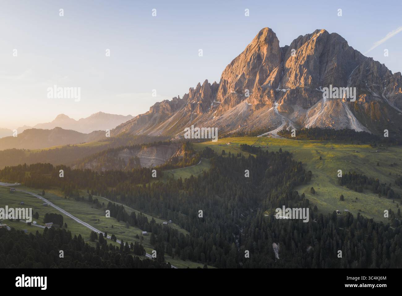 Aerial view of golden sunlight kissing the rugged peaks and verdant ...