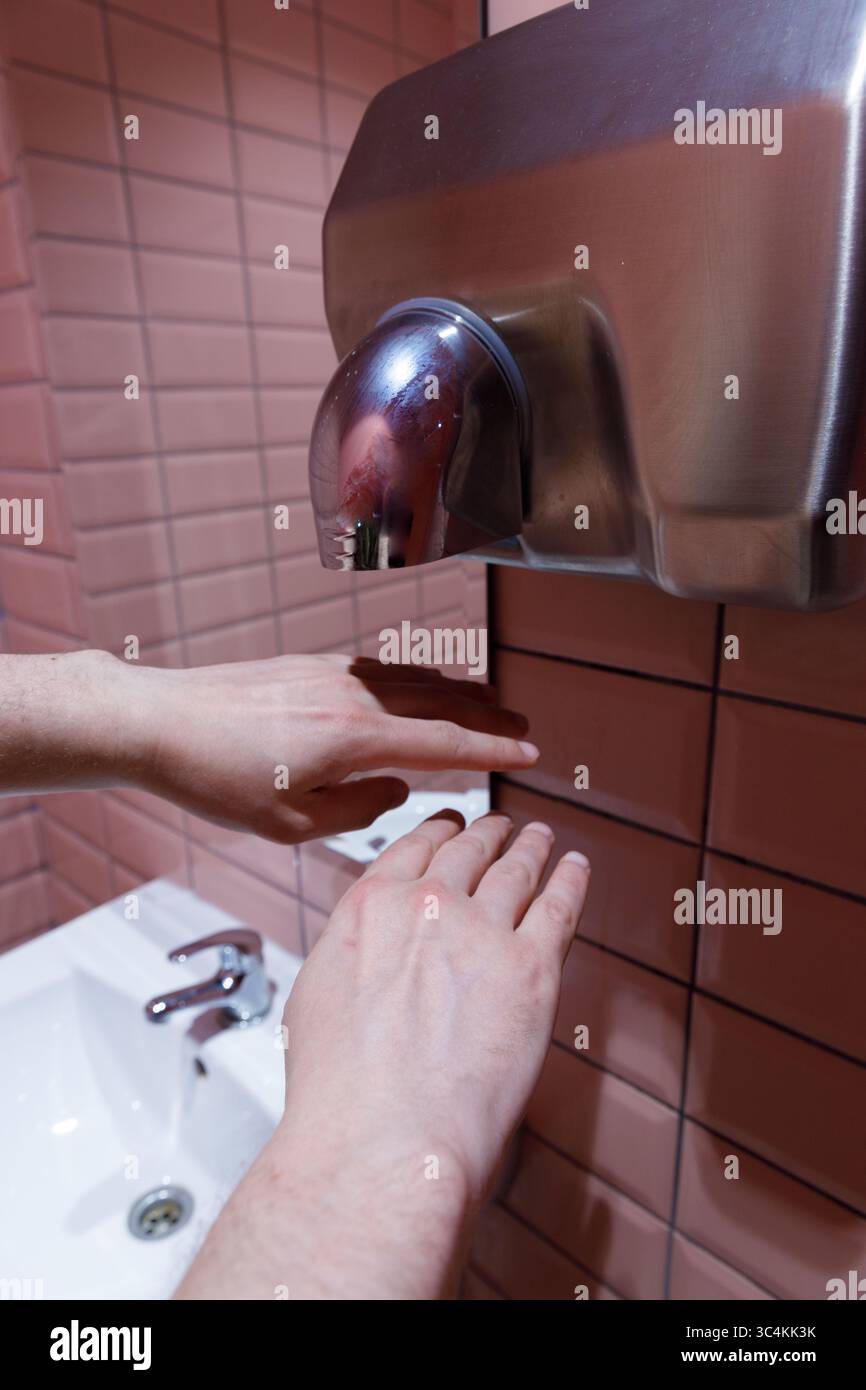 Hands Positioned Under Modern Hand Dryer in a Stylish Restroom with ...
