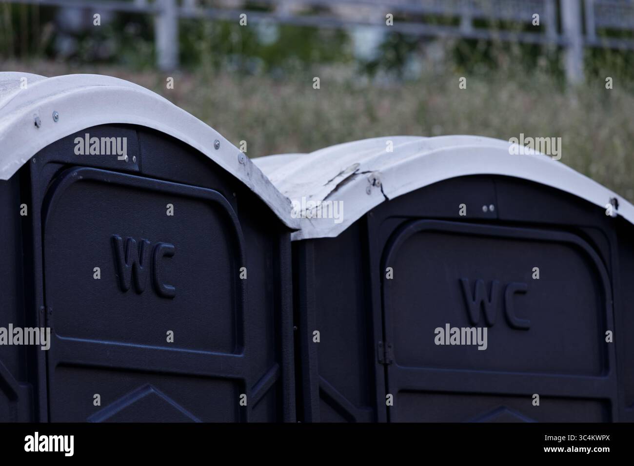 Two Portable Toilets with Engraved WC Signage in an Outdoor Setting ...