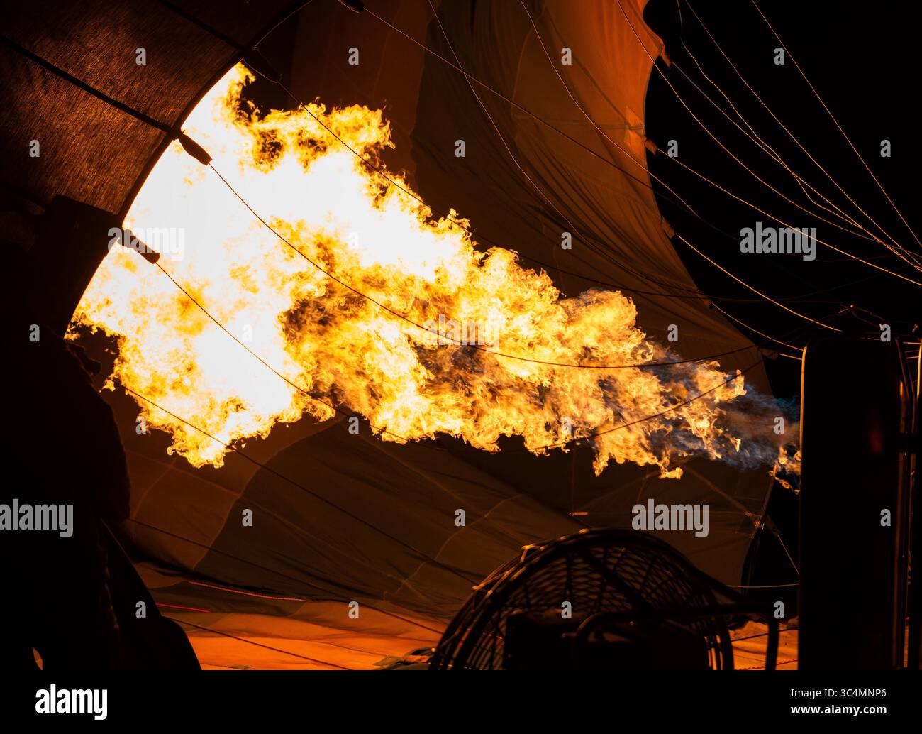 Closeup detail of hot air balloon filling in early morning dawn light ...