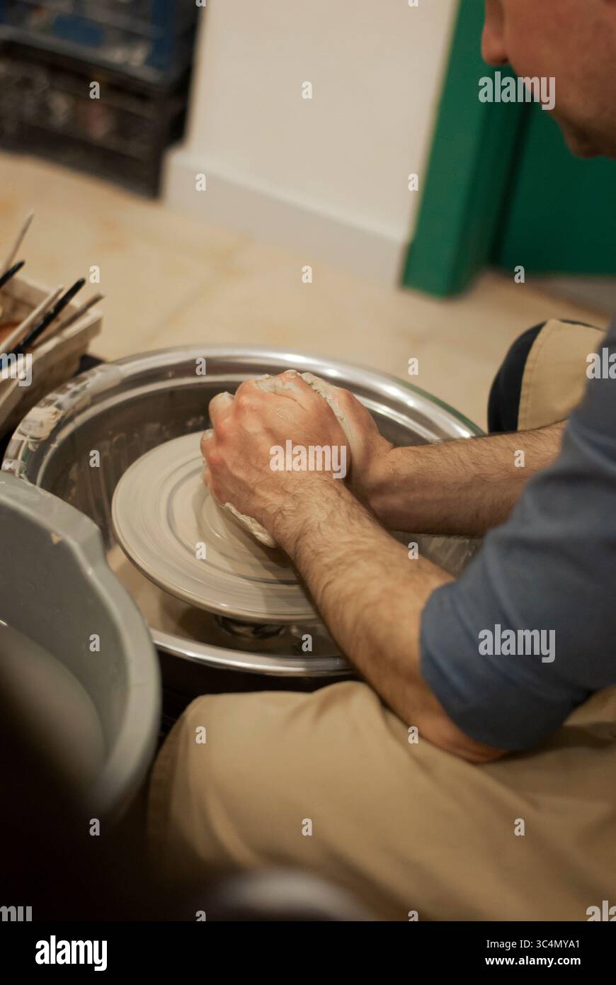 Wet clay on wheel forming a cup Stock Photo - Alamy